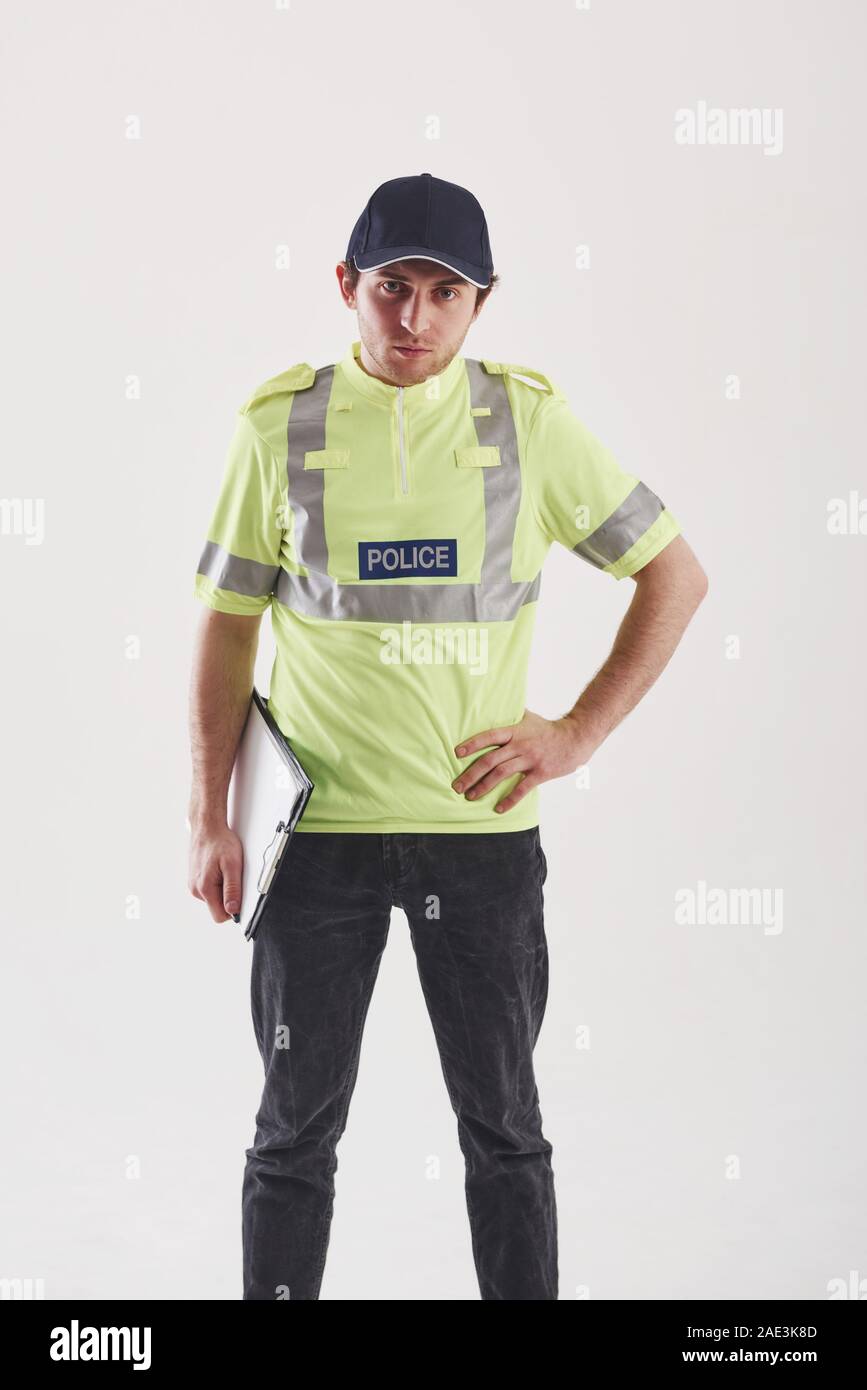 Waiting for the task. Policeman in green uniform stands against white ...