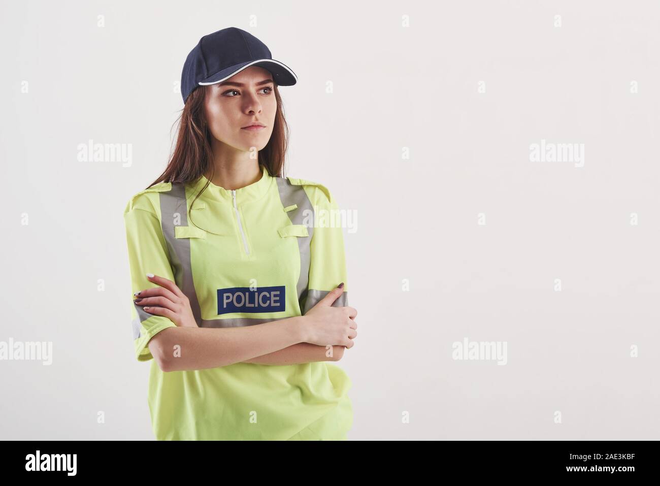 On guard of order. Pretty woman in green police uniform stands against ...