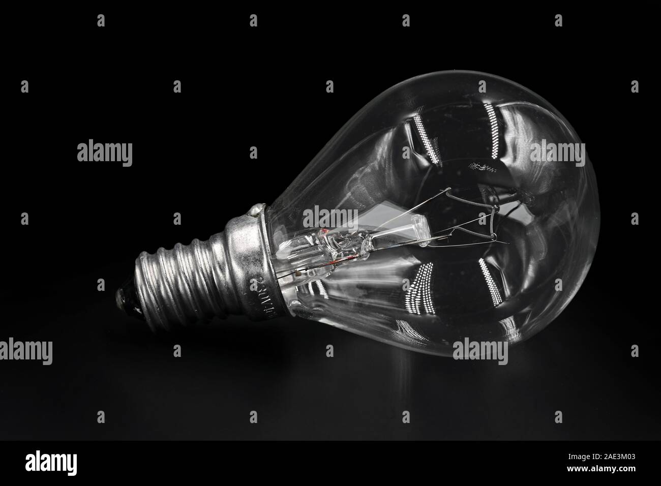 Clear light bulb lying on side on black background Stock Photo - Alamy