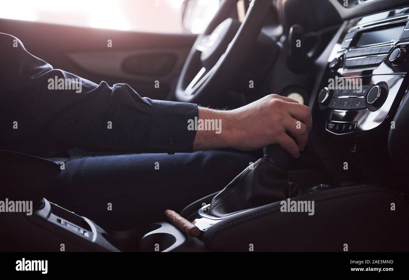 Close up side view of man sitting in the modern car with black interior ...