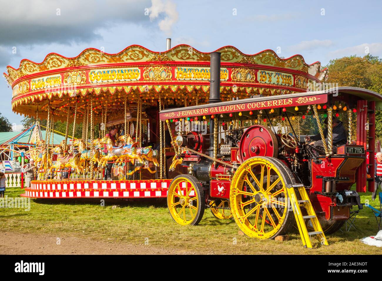 Steam driven vintage carousal with hobby horses being driven by a ...
