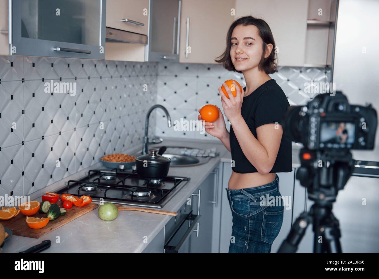 The backstage of photoshoot. Girl in the modern kitchen at home at her ...