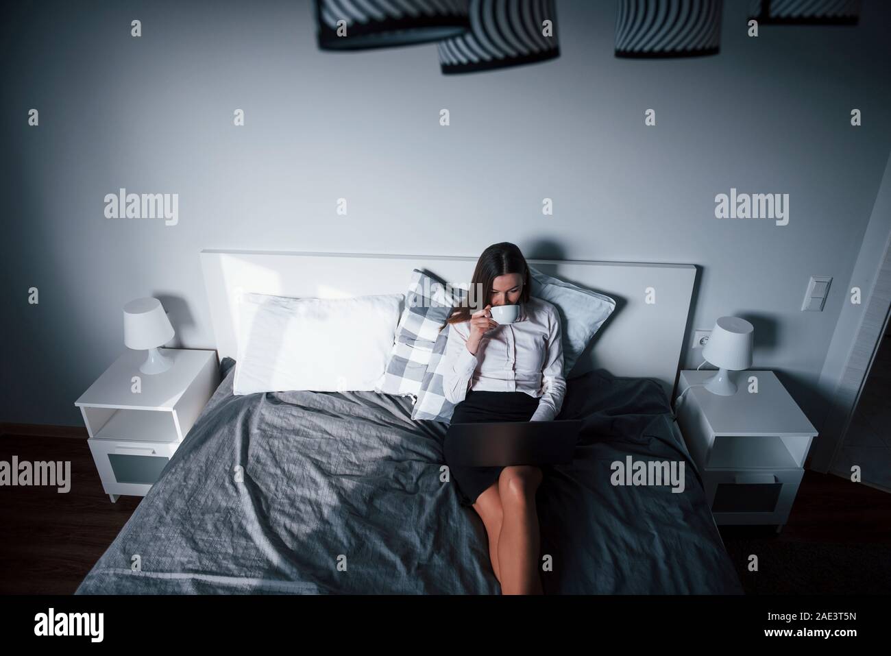 View from above. Pretty young woman lying on the bed at morning time in ...