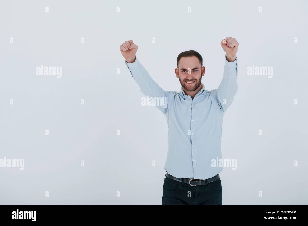 With hands up. Have success. Man in official clothes stands against ...