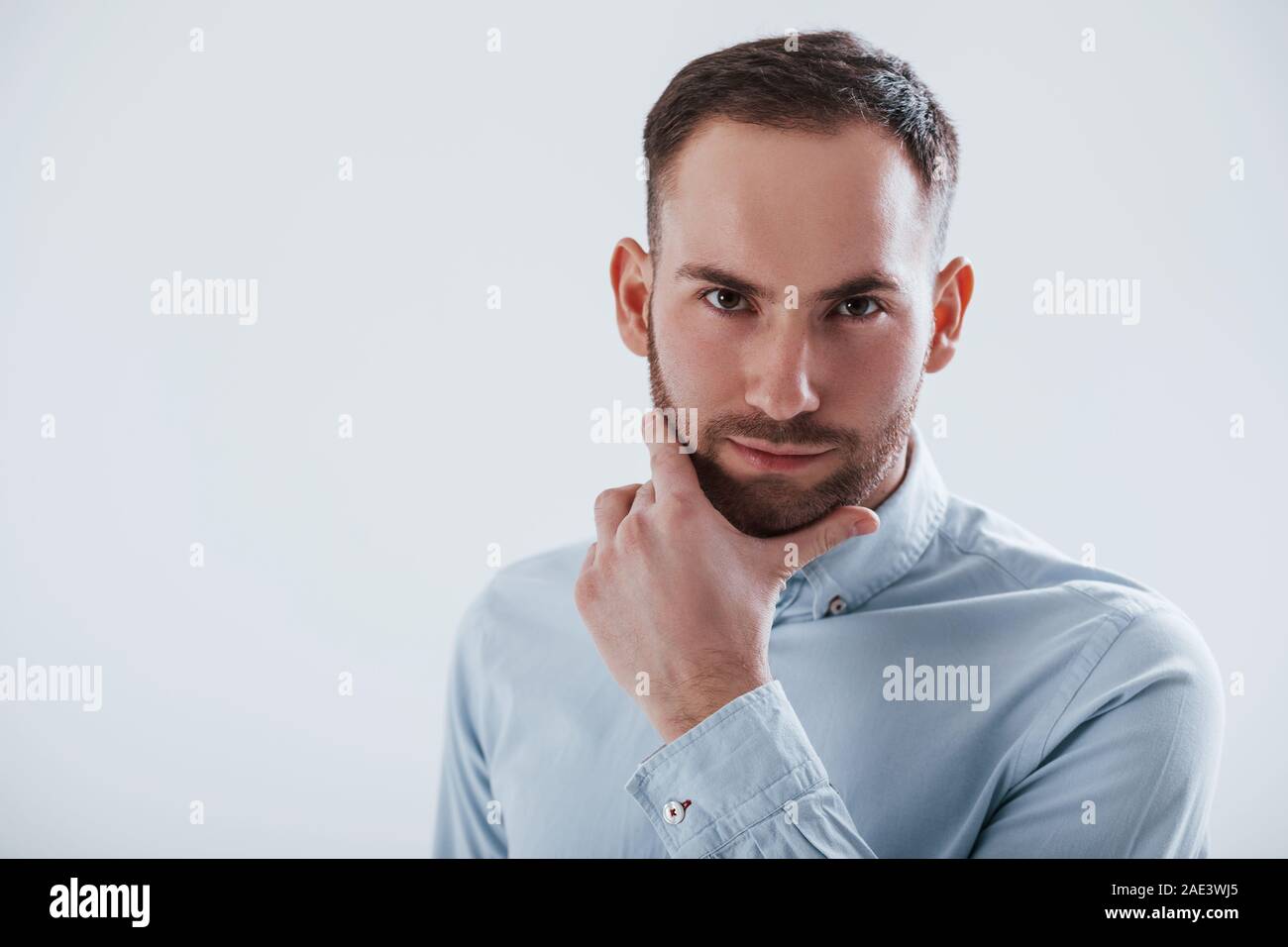 Nice portrait. Man in official clothes stands against white background ...