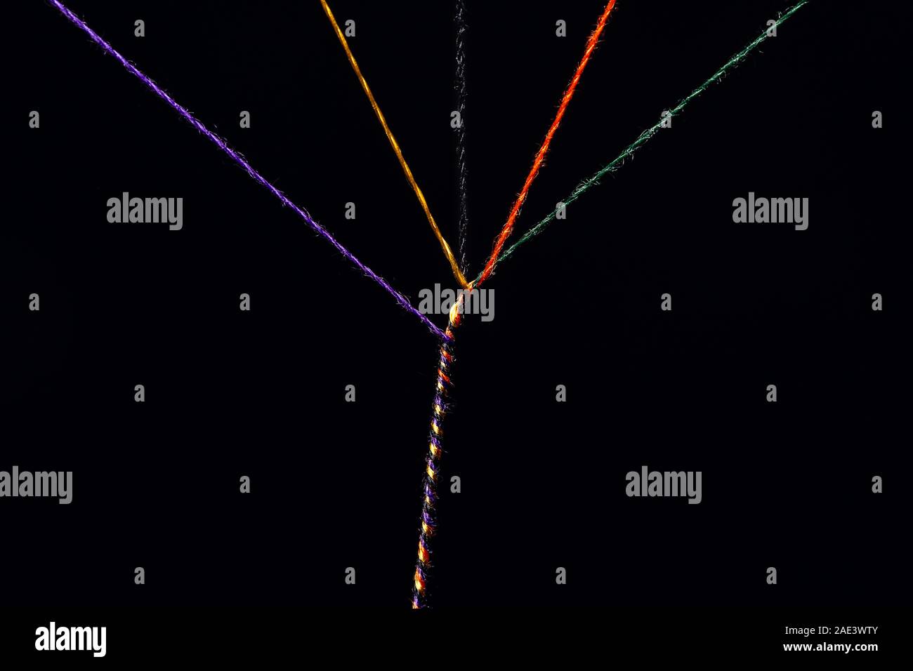 5 various colored threads which are twisted into a single thick multi ...