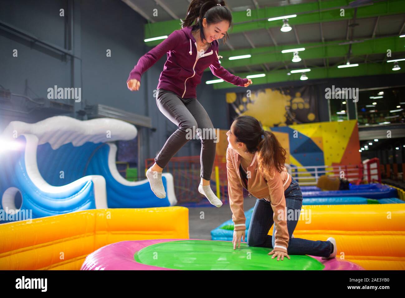 Happy young women jumping on trampoline Stock Photo - Alamy