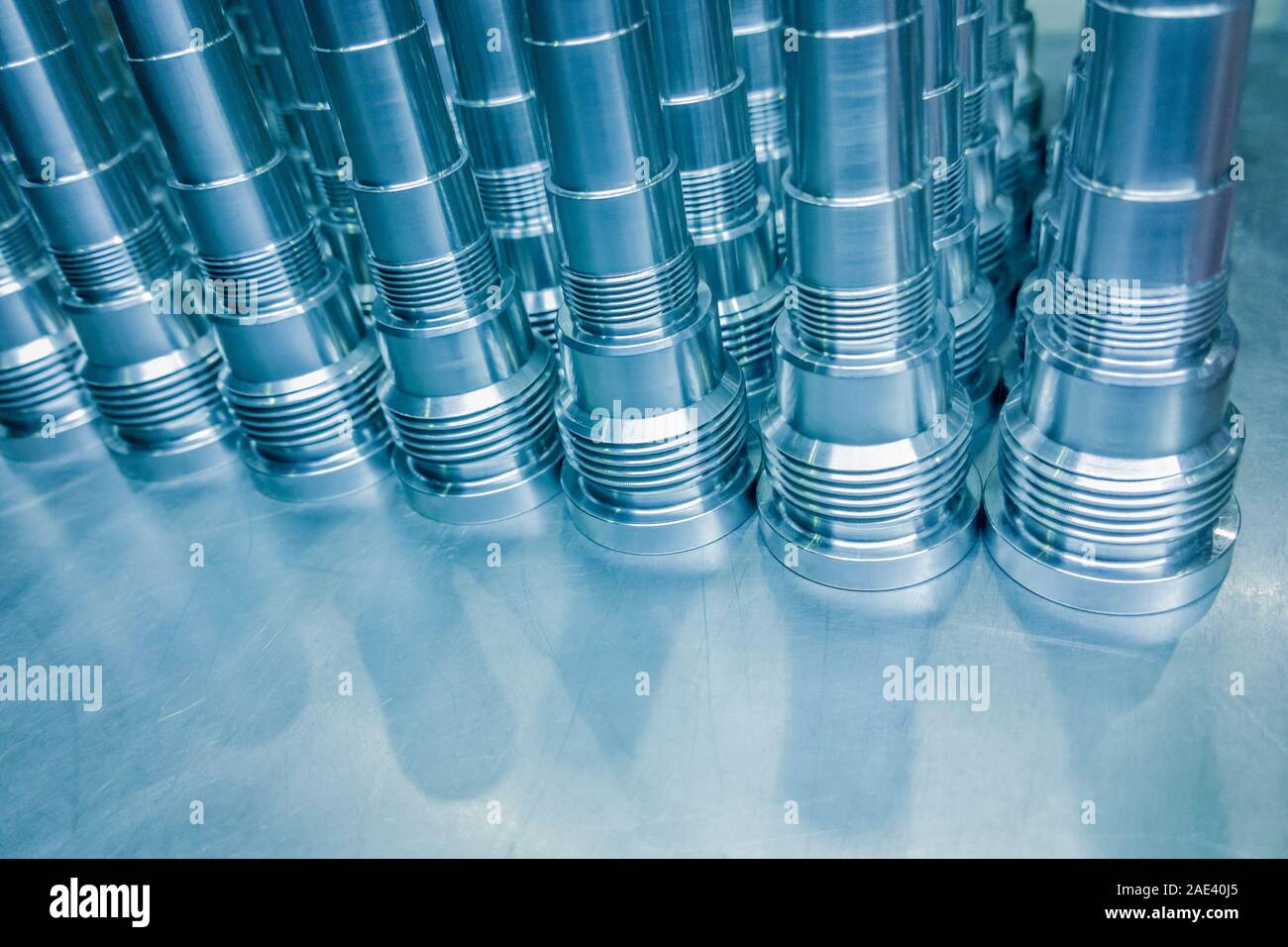 Shiny blue steel parts background, long clean steel rods after fine cnc ...