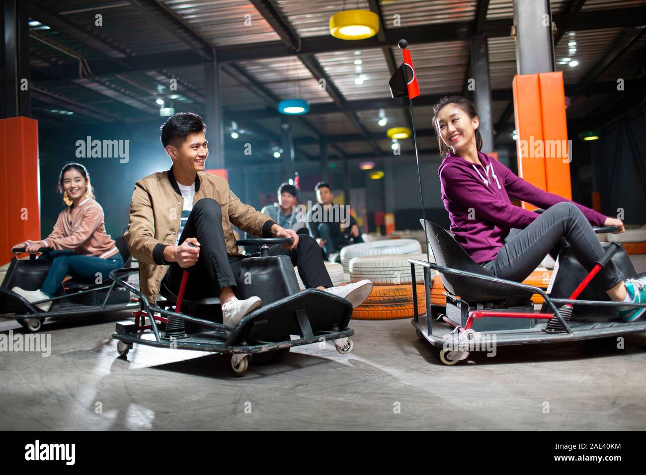 Happy young friends driving go-carts Stock Photo - Alamy