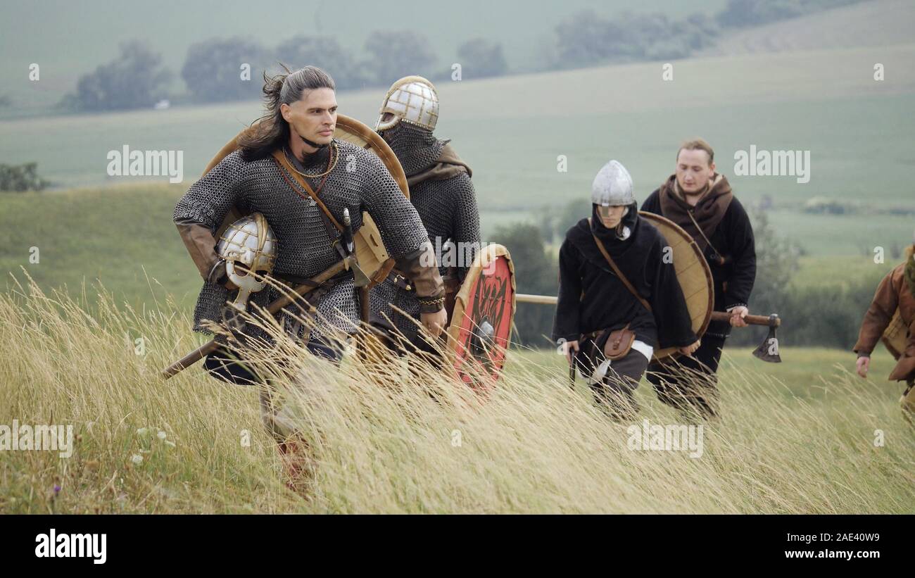 Group of Medieval Viking with shields walking forward on the meadow ...