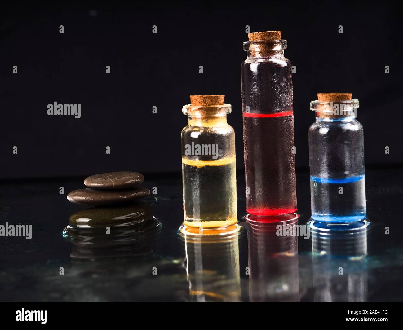 Three colourful liquid glass vial with black background for medical ...