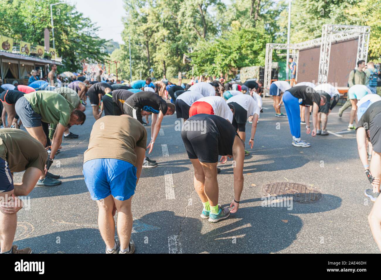 Adults are doing physical exercises in the park, Ukraine. Group sport ...