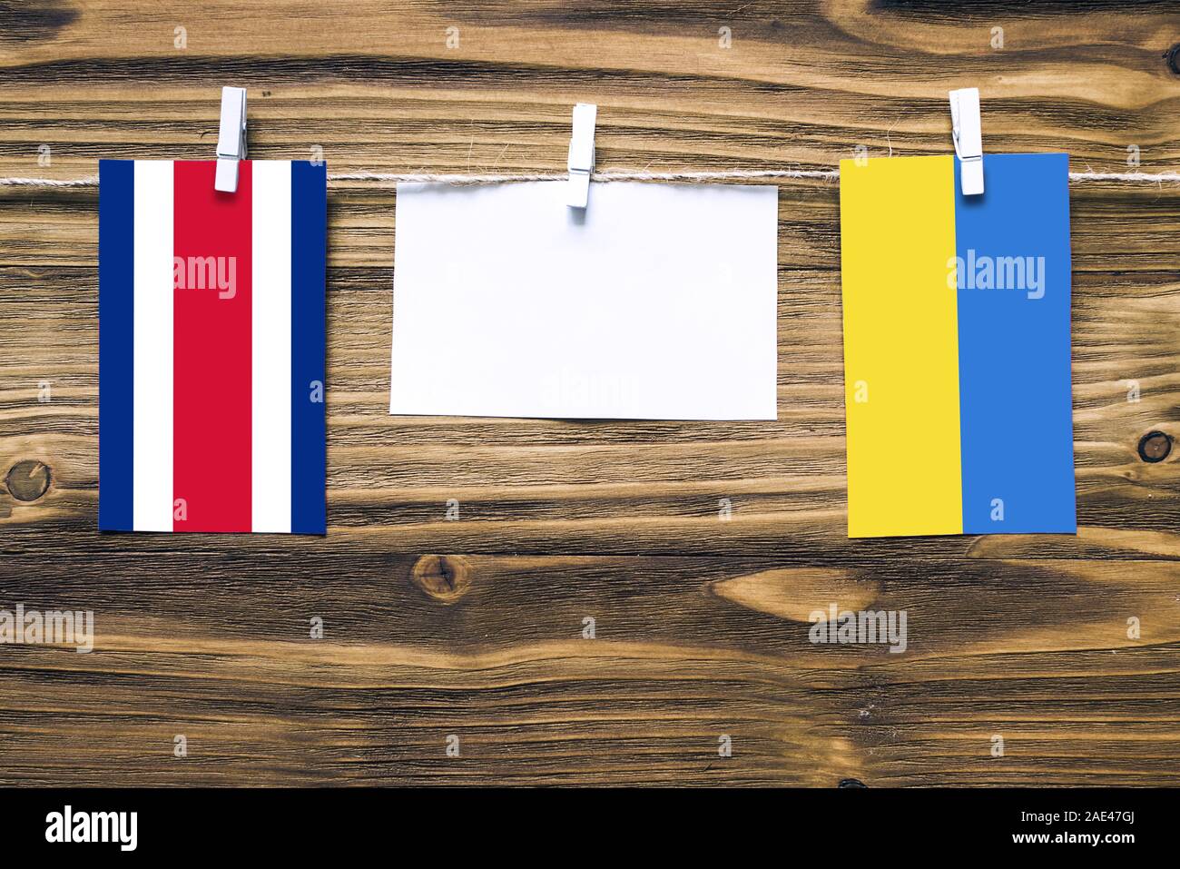 Hanging flags of Costa Rica and Ukraine attached to rope with clothes ...