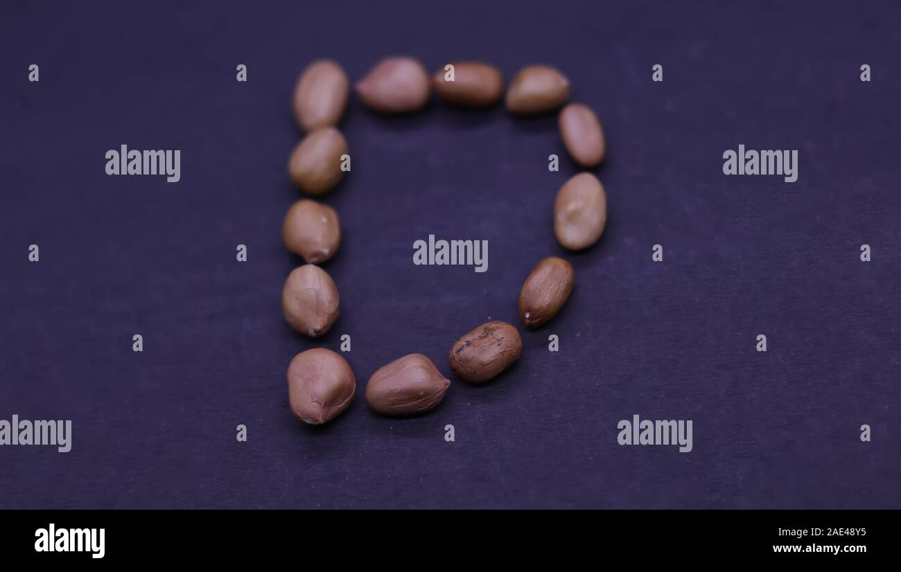 'D' text of the peanuts on the black background. Symbol of letter Stock ...