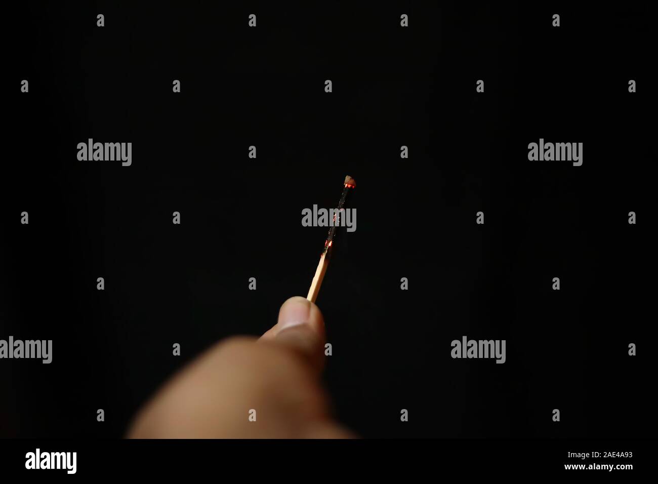 Burnt extinguished match held in hand on black rugged backgrounds Stock ...