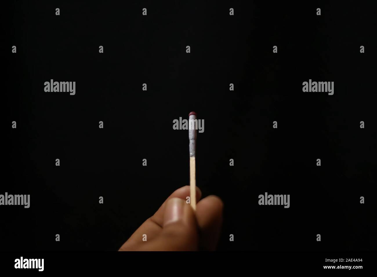hand holding lit matchstick on black backgrounds Stock Photo - Alamy