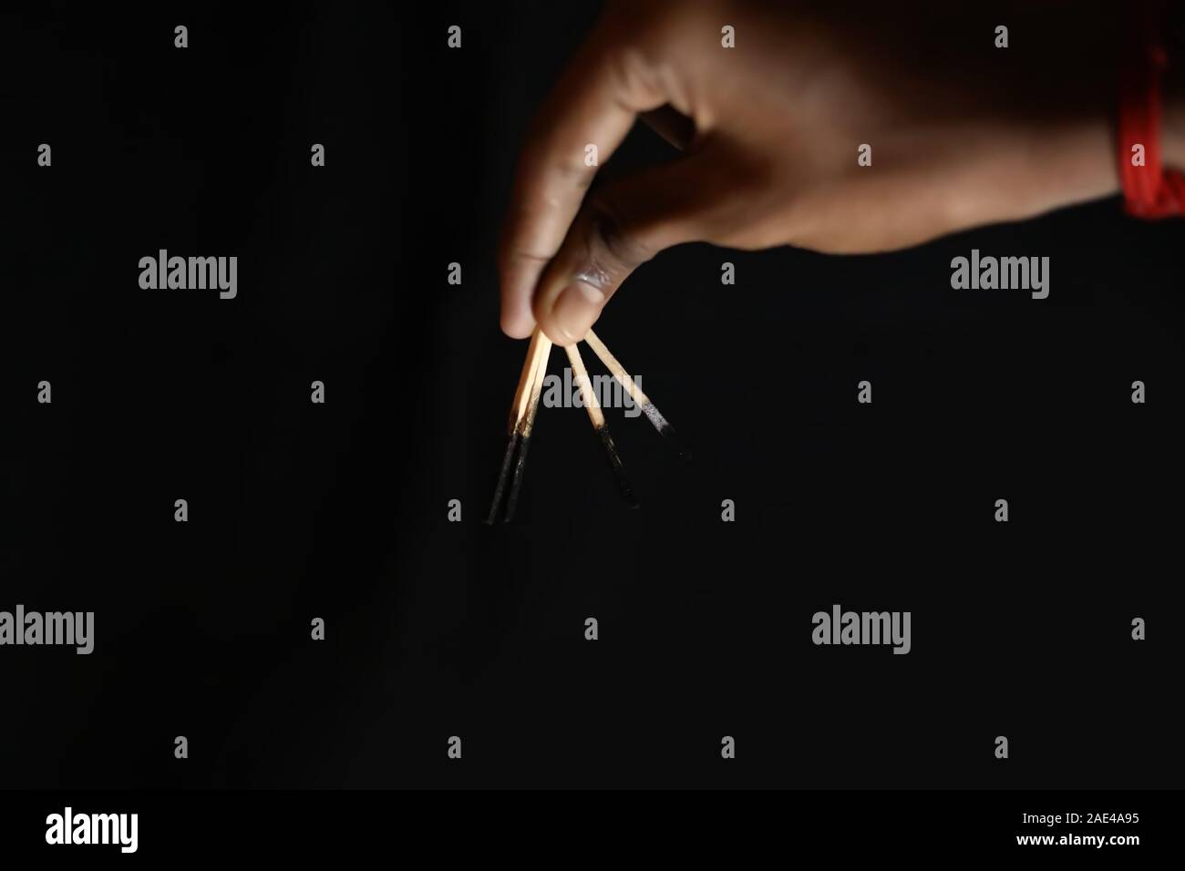 Hand holding an extinguished matchstick on black background Stock Photo ...