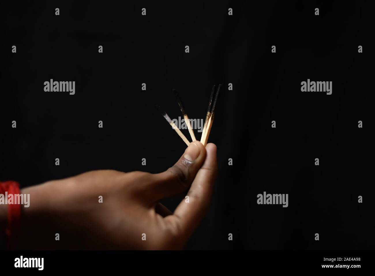 Hand holding an different extinguished matchstick Stock Photo - Alamy