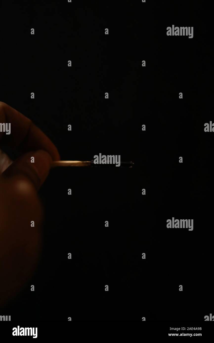 Hand holding an extinguished matchstick on black backgrounds Stock ...