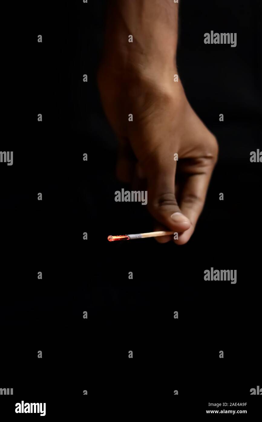 Burnt extinguished match held in hand on black rugged backgrounds Stock ...