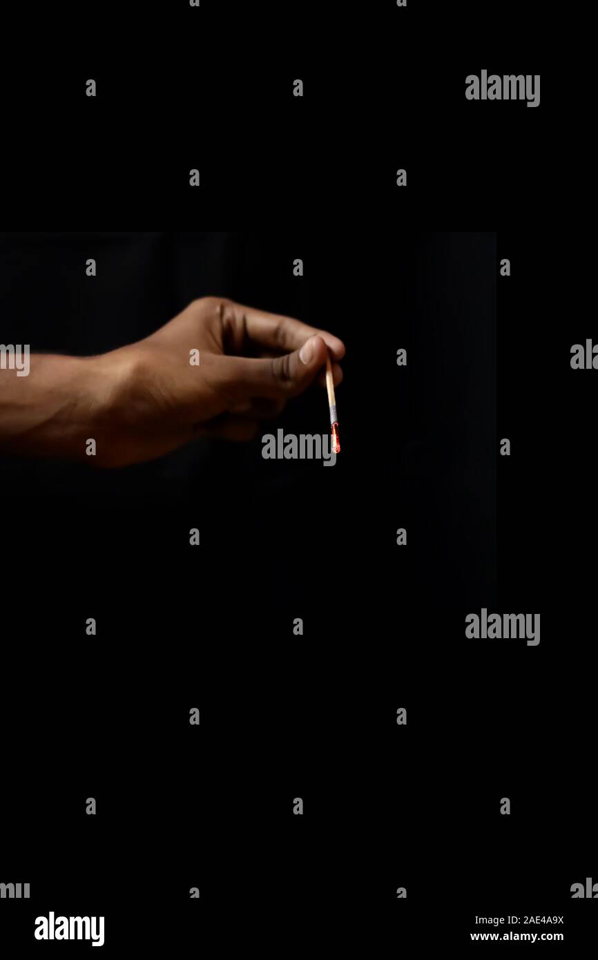 Hand holding an extinguished matchstick on black backgrounds Stock ...