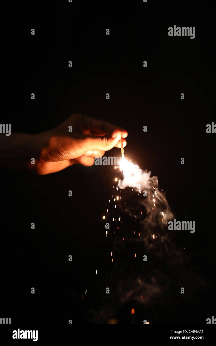 Hand holding burning Sparkler blast on a black backgrounds Stock Photo ...