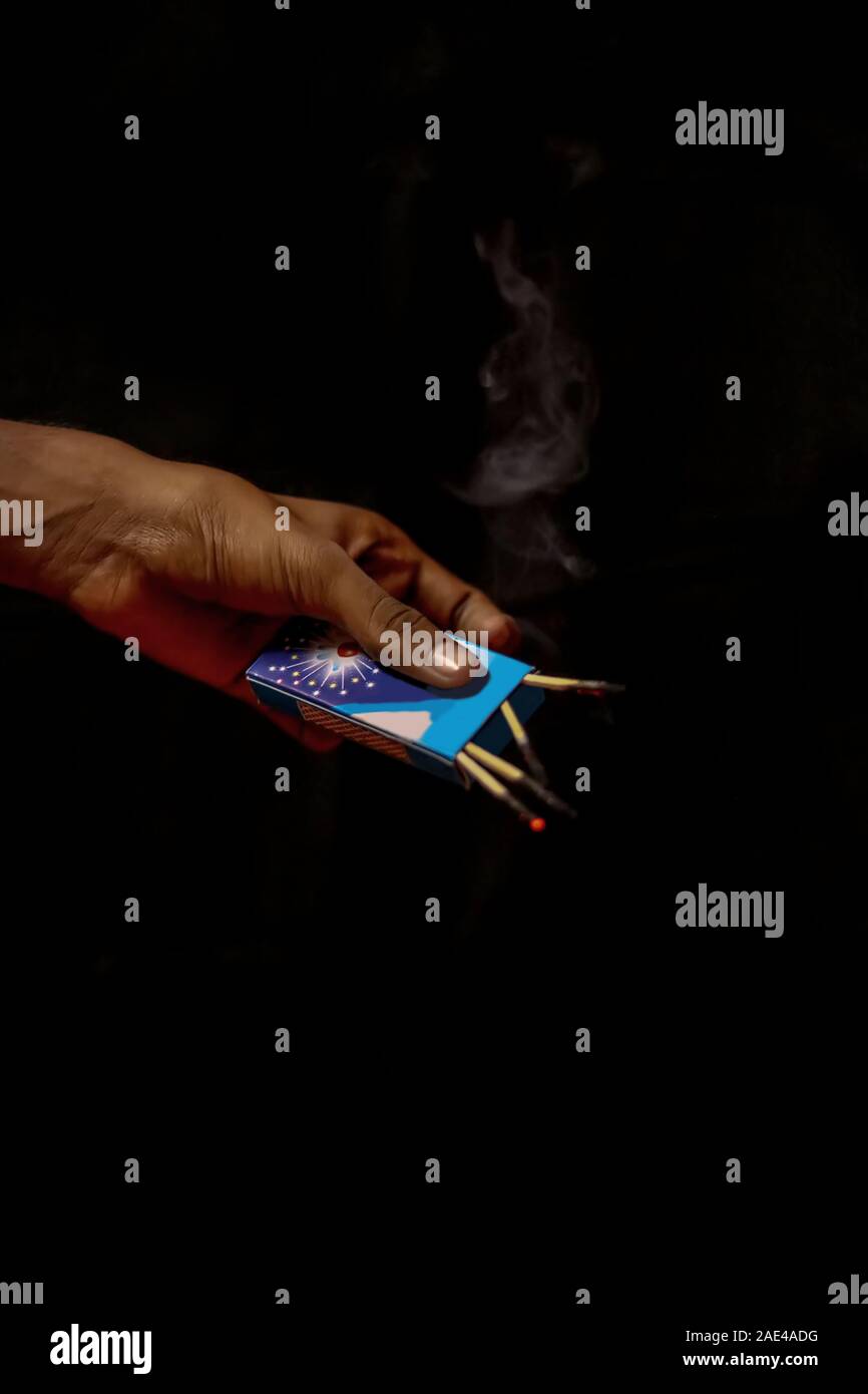 Hand holding an extinguished matchstick on black backgrounds Stock ...