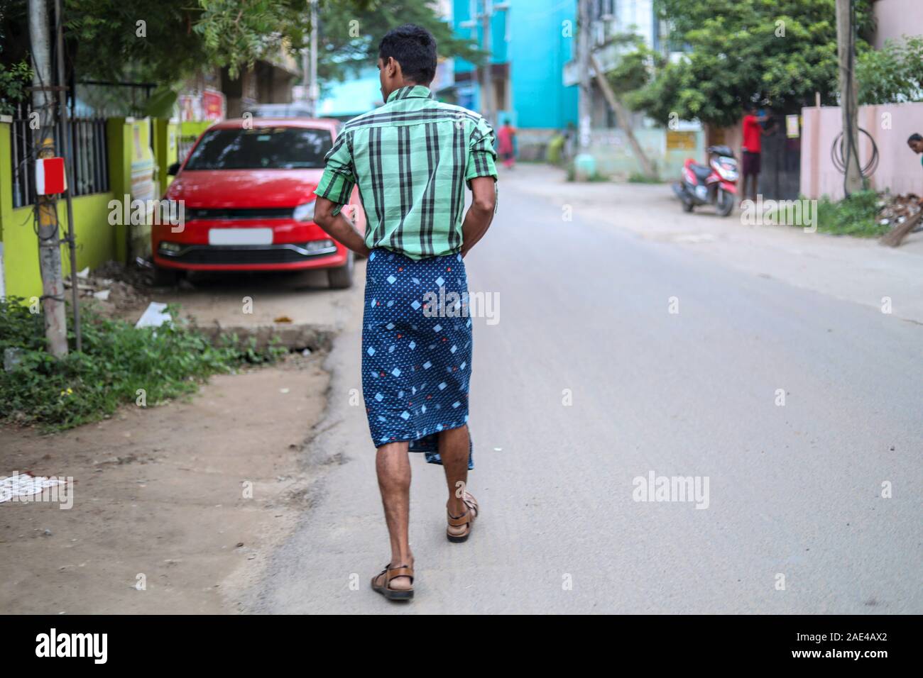 Back view Indian young man walking on streets Stock Photo - Alamy