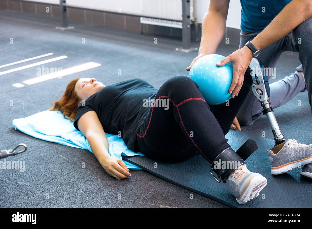Personal trainer assisting woman with disabilities in her workout ...