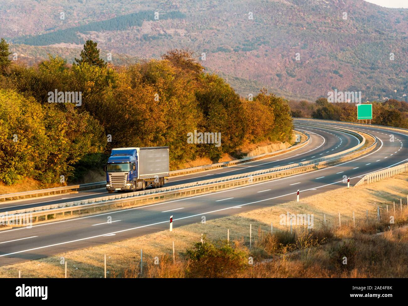 Single lorry truck on a country highway under amazing orange sunset sky ...