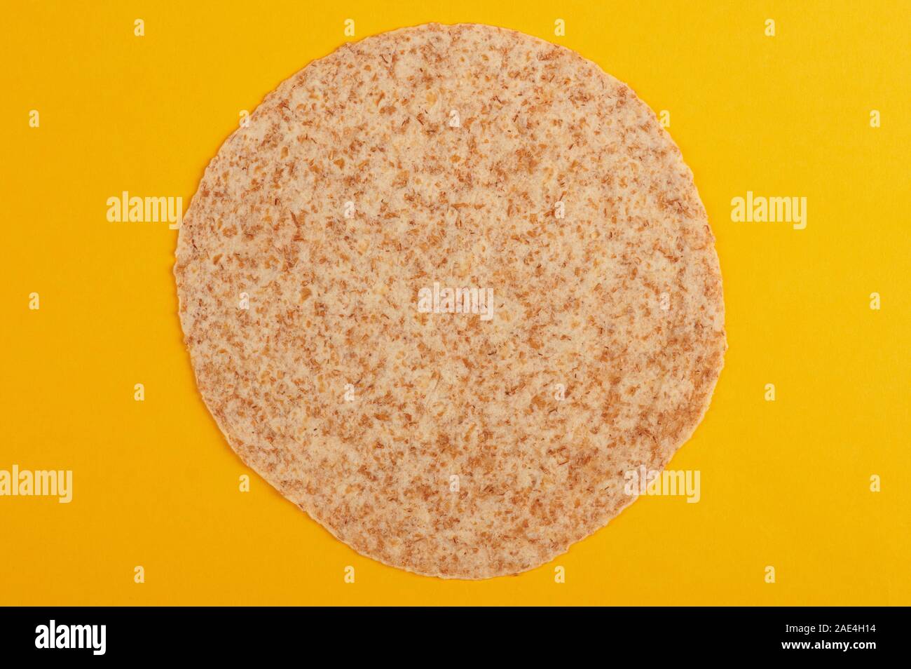 One round tortilla isolated on yellow background Stock Photo - Alamy