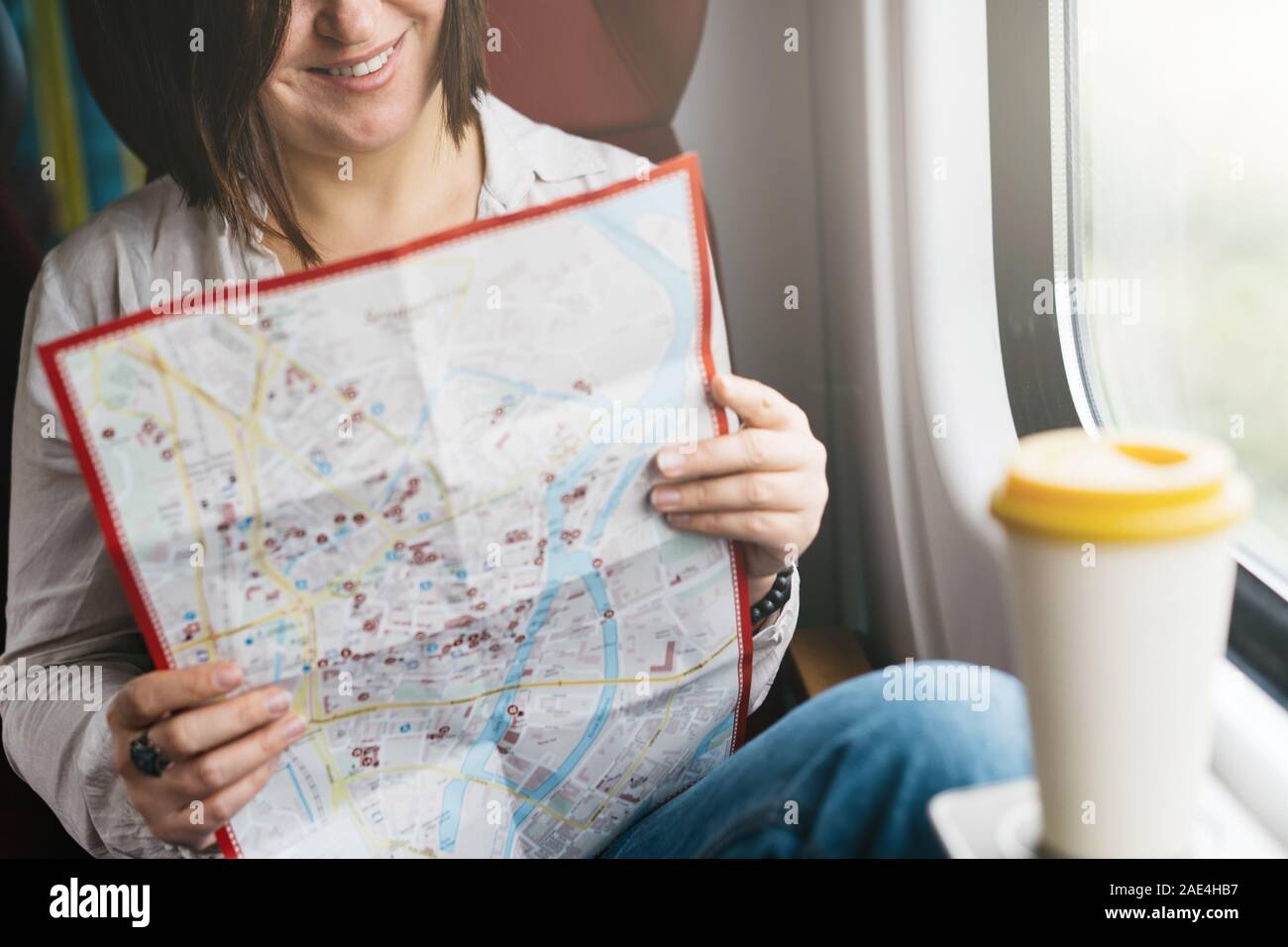 A smiling woman in a suburban train studies the map and smiles Stock ...