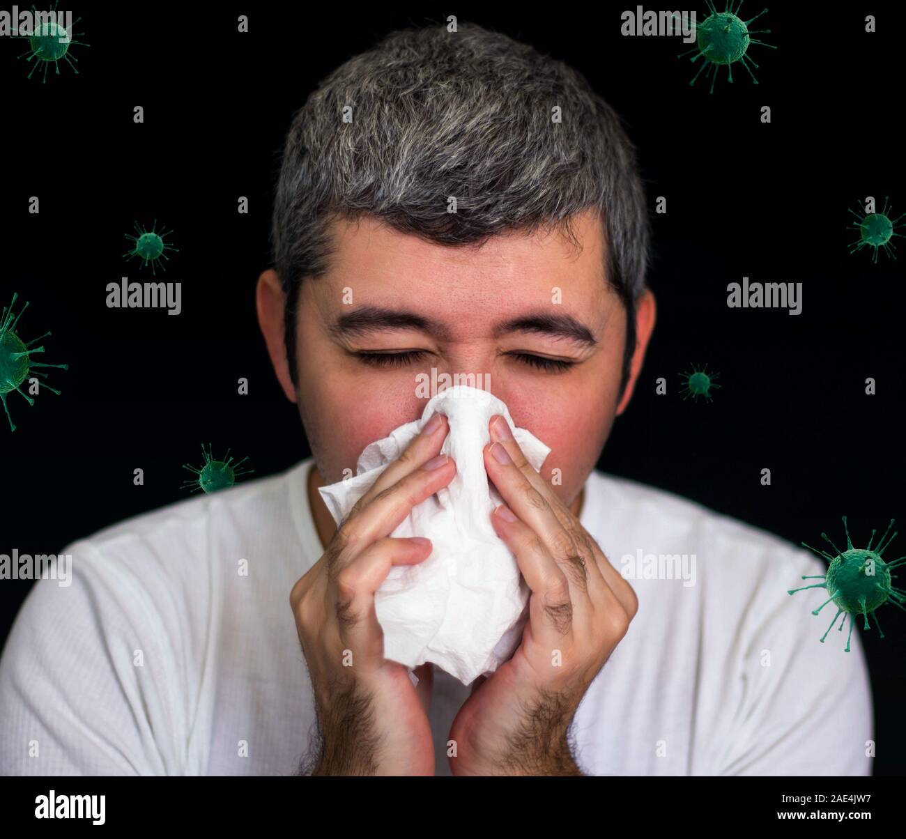 Sick man blowing nose into tissue, viruses all around Stock Photo - Alamy