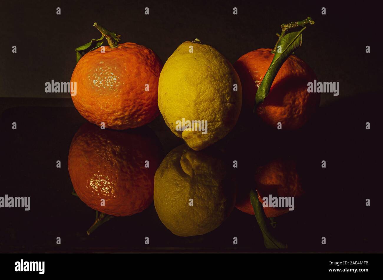 Clementines and lemon fruit still life on black background Stock Photo ...