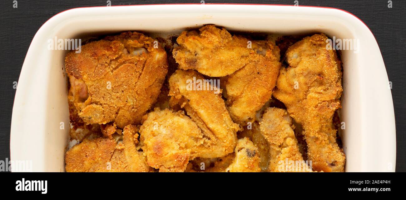 Delicious homemade oven baked fried chicken in a dish over black ...