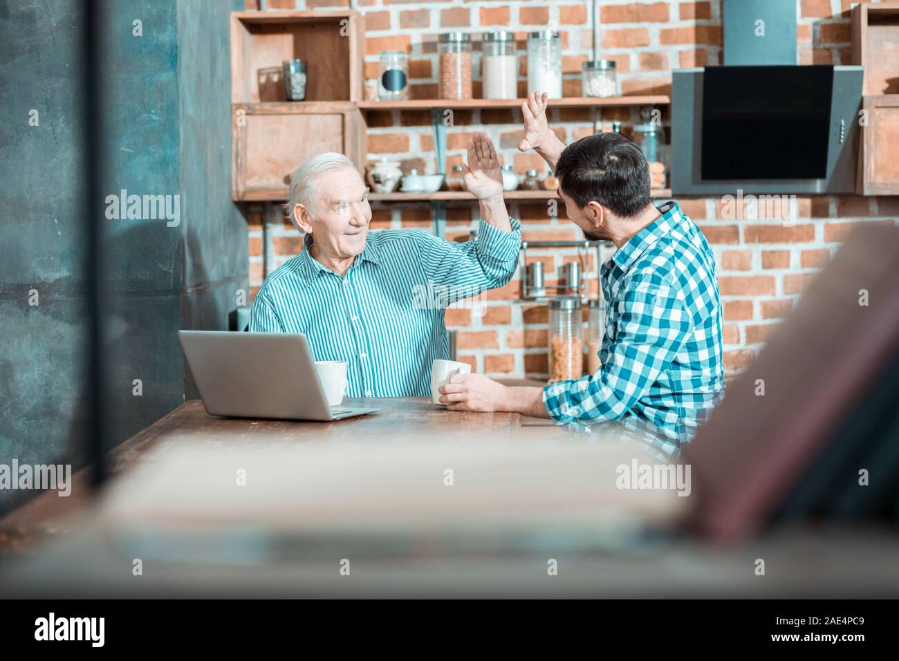 Nice positive father and son giving high five Stock Photo - Alamy