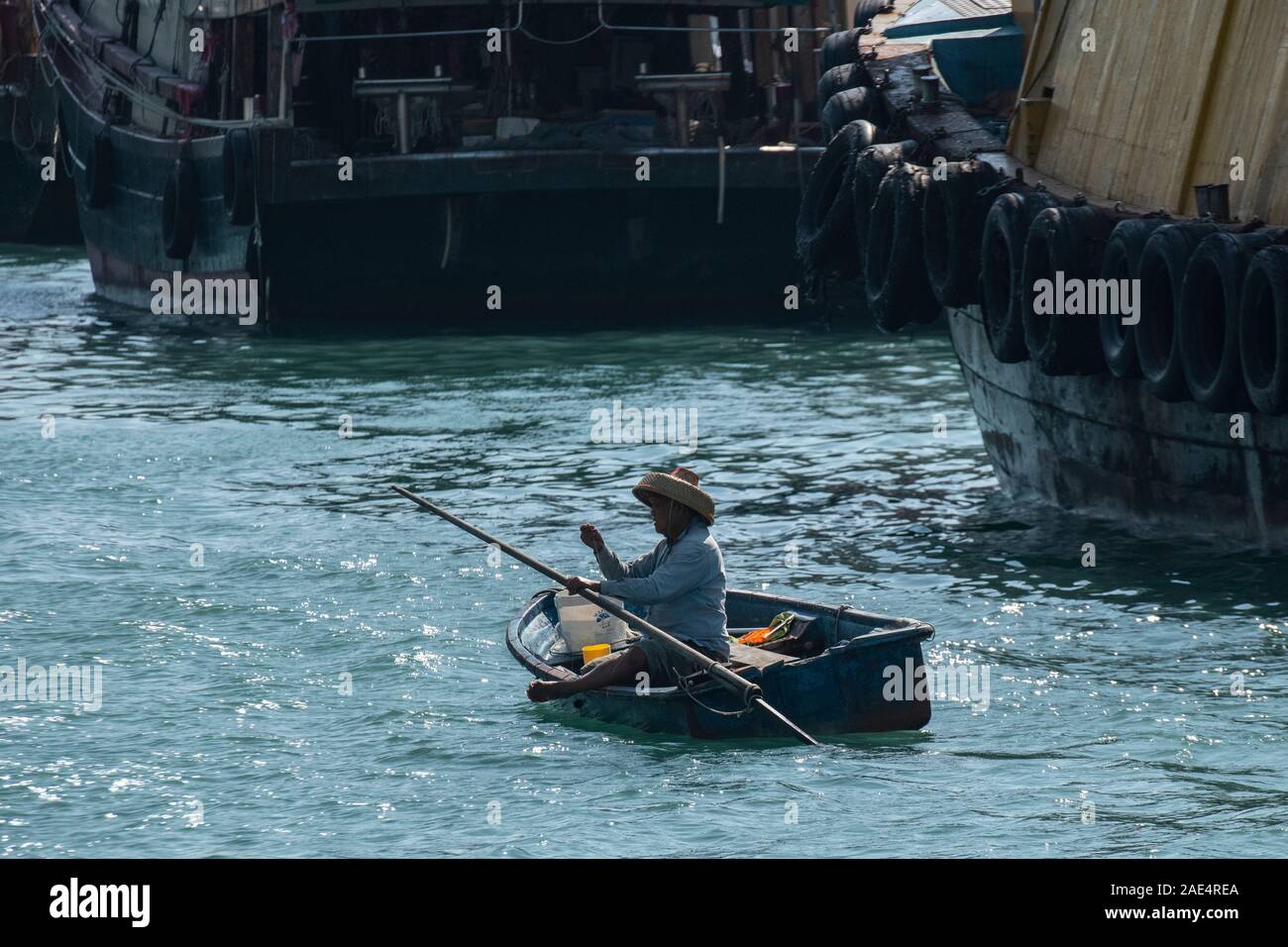 A commercial fisherman uses a hand line on a very small fishing boat in ...