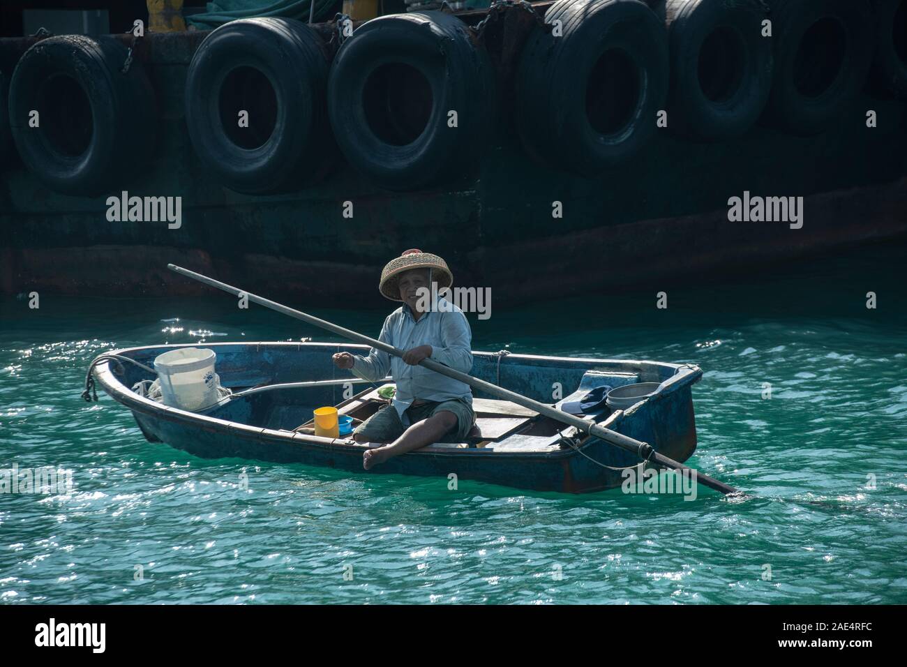 A commercial fisherman uses a hand line on a very small fishing boat in ...