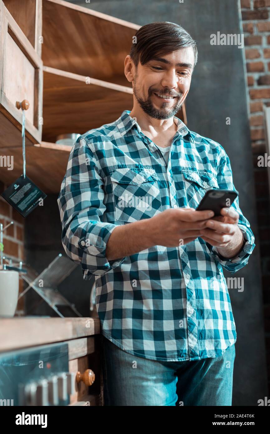 Happy delighted man using his device Stock Photo - Alamy