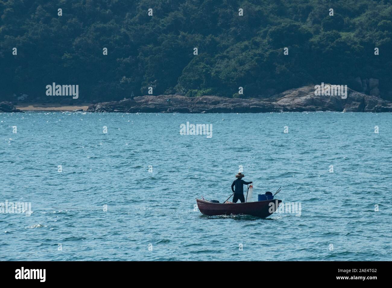 A commercial fisherman using hi nets on a very small fishing boat ...