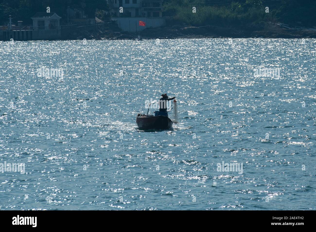 A commercial fisherman using hi nets on a very small fishing boat ...
