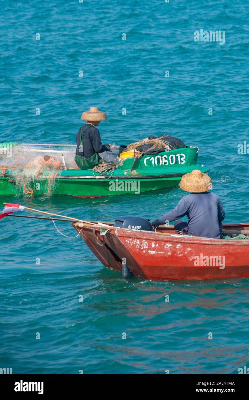 A commercial fisherman using nets on a very small fishing boat - Hong ...