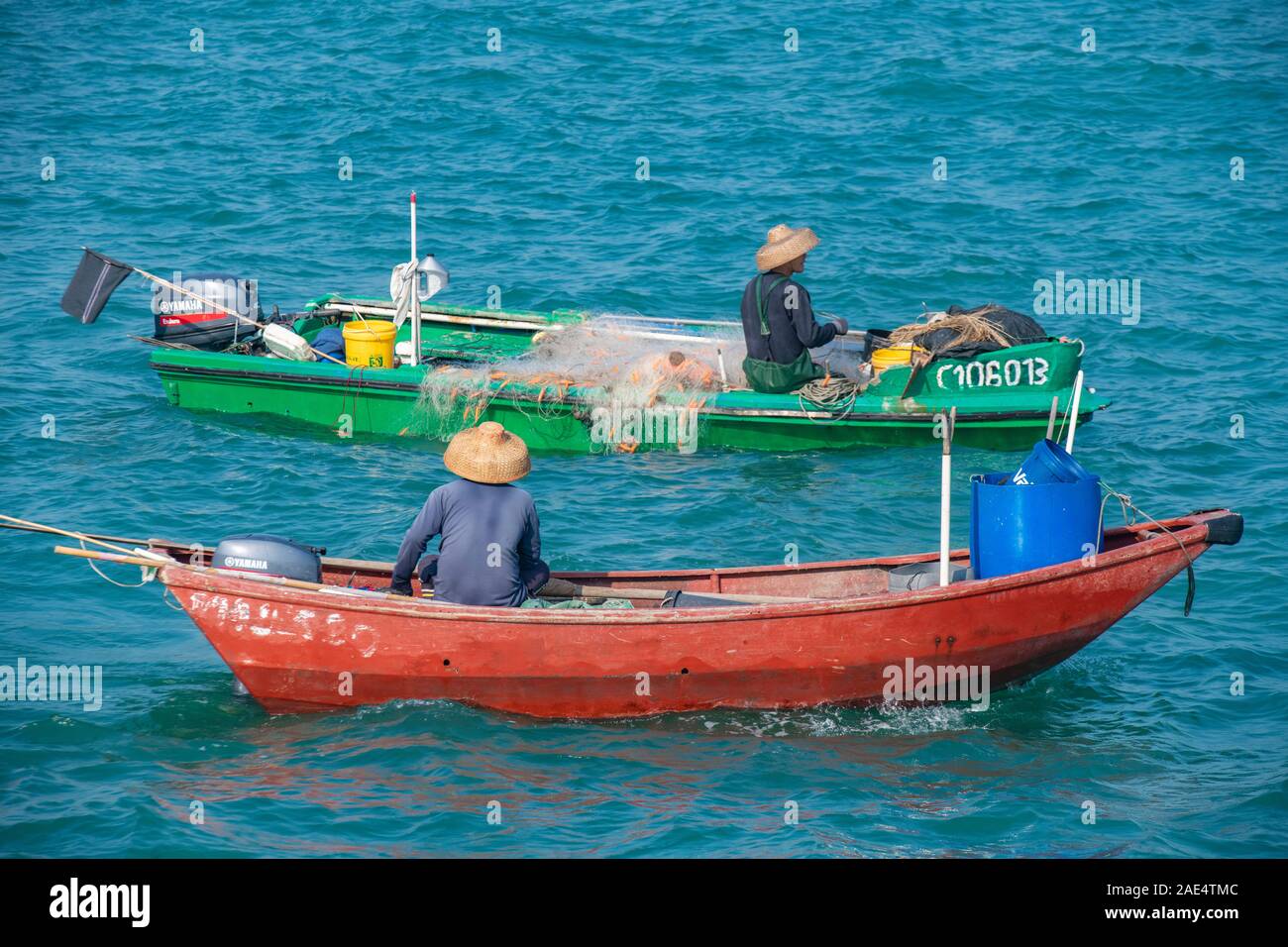 A commercial fisherman using nets on a very small fishing boat - Hong ...