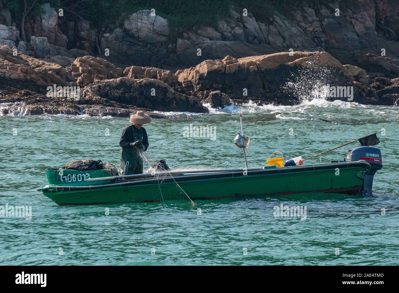 A commercial fisherman using hi nets on a very small fishing boat ...