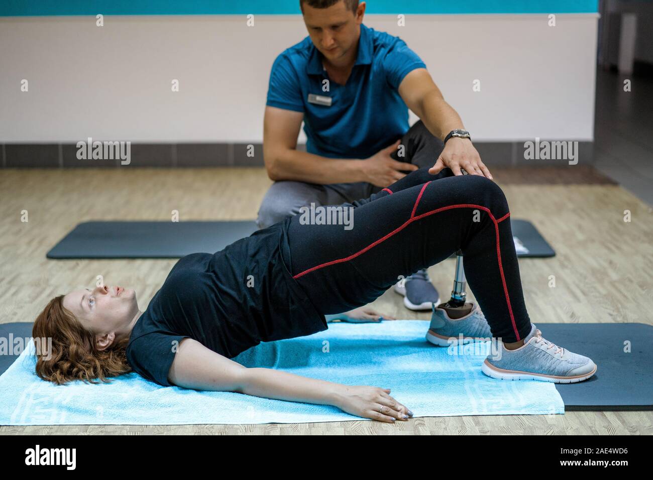 Personal trainer assisting woman with disabilities in her workout ...