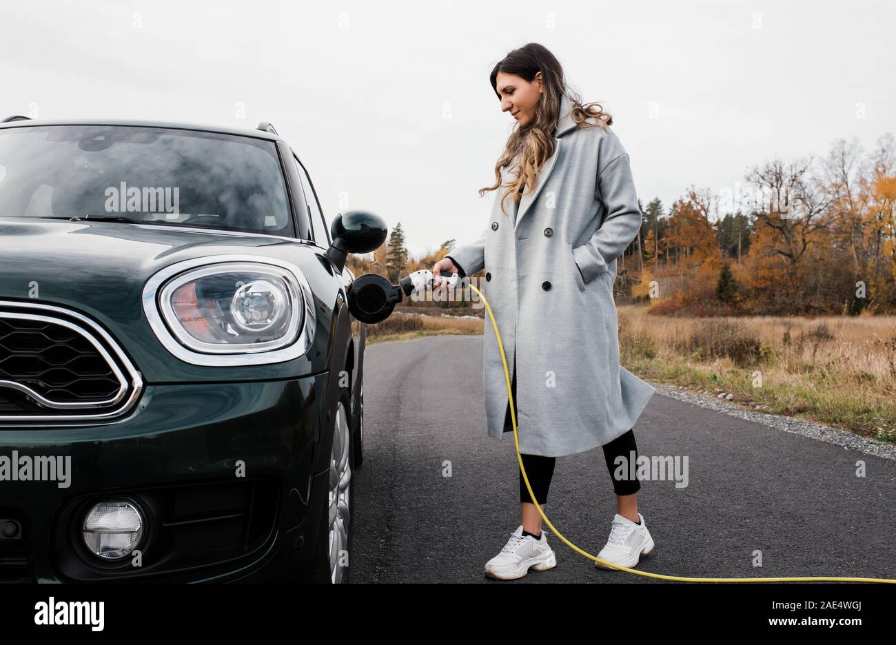 Woman plugging in electric car hi-res stock photography and images - Alamy