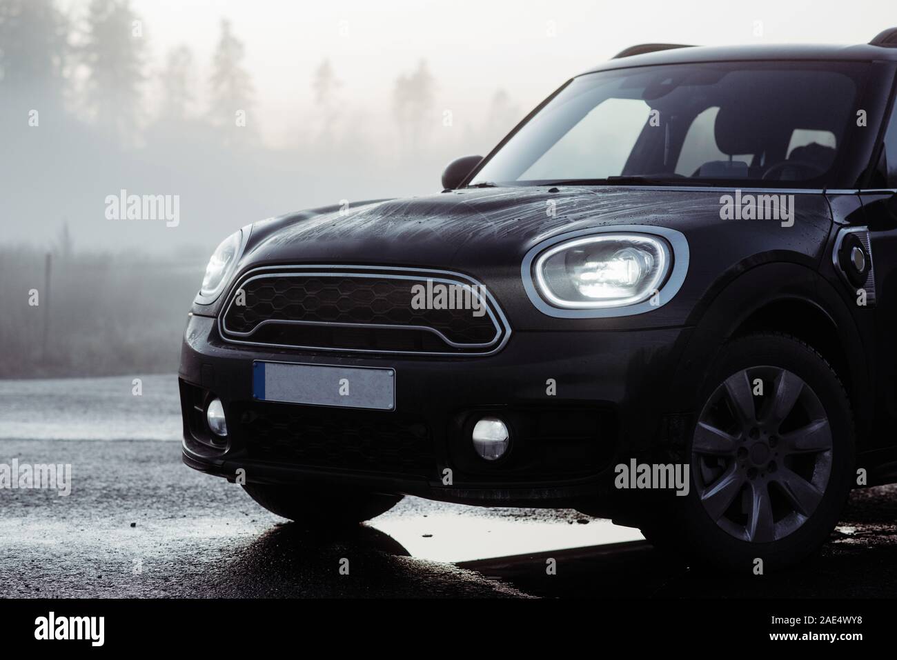 front view of a mini car and it's headlights on a frosty country road ...