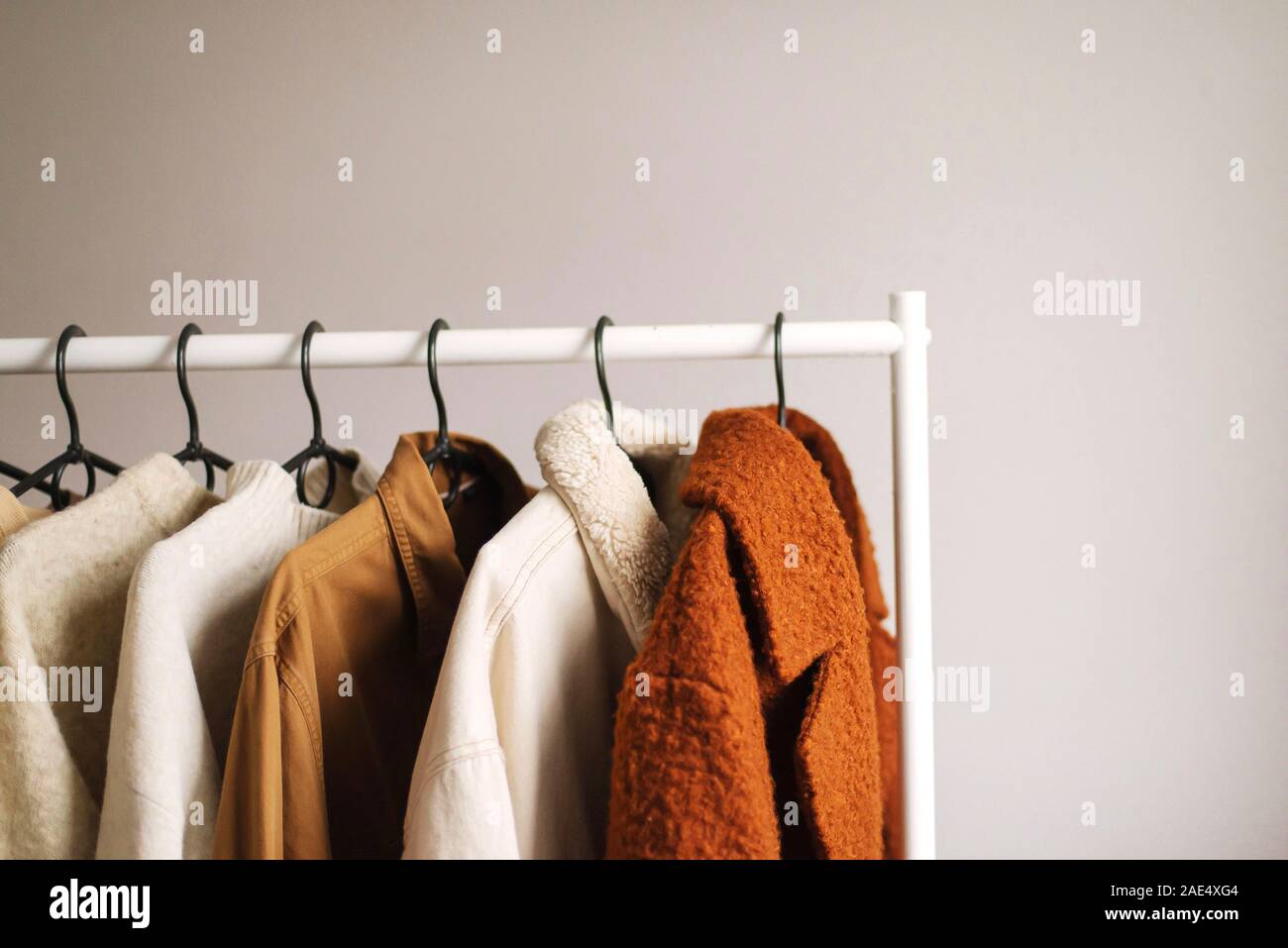 Rack filled with clothing on white background Stock Photo - Alamy