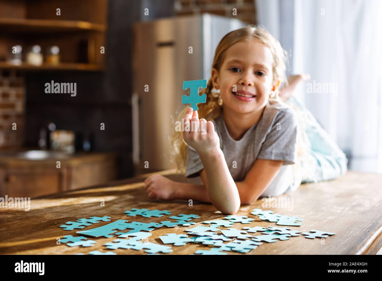 Cute smiling little girl playing with puzzles Stock Photo - Alamy