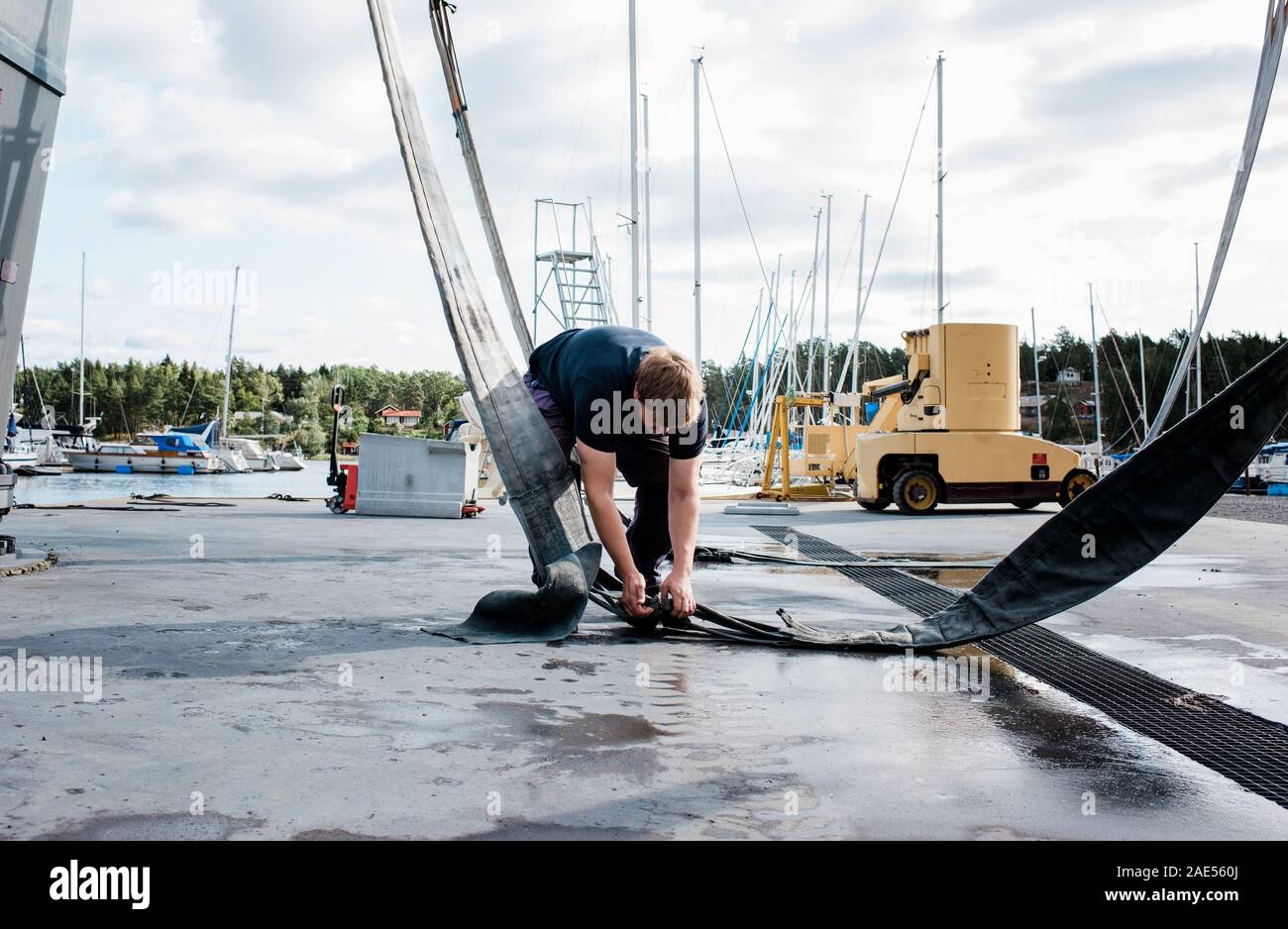 Marine engineer technician working outside in a marina moving boats ...